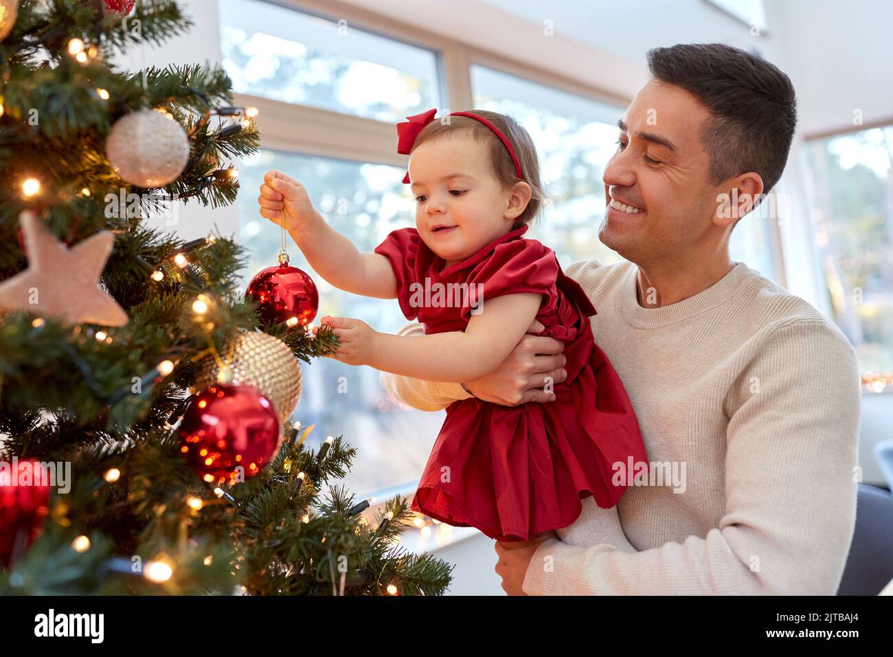 happy father and baby girl decorate christmas tree Stock Photo - Alamy