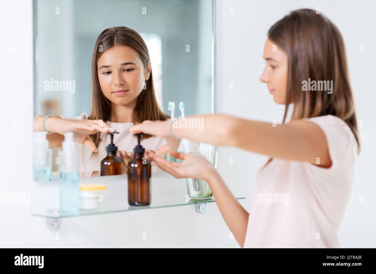 teenage girl squeezing liquid soap at bathroom Stock Photo - Alamy
