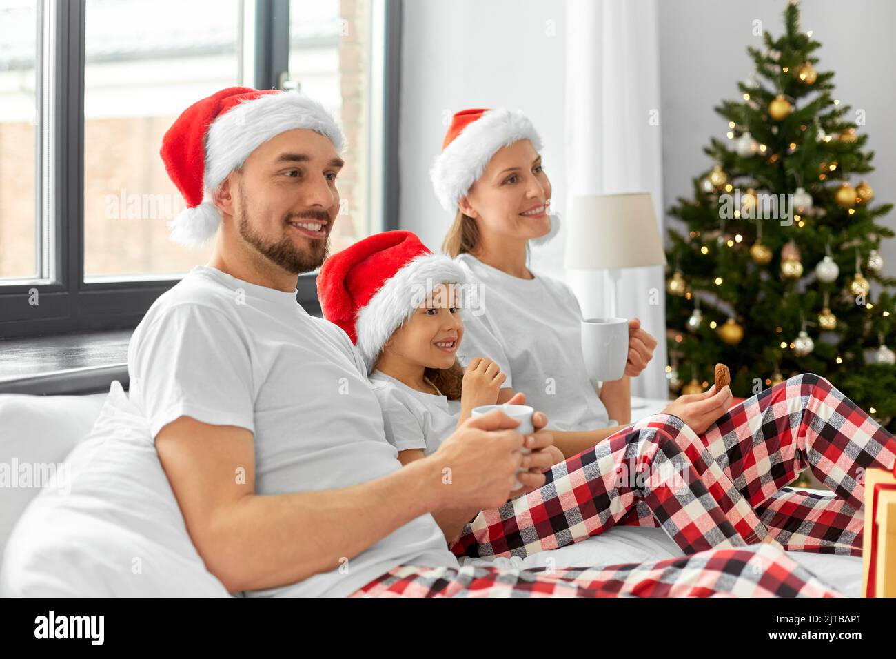 happy family eating cookies in bed on christmas Stock Photo - Alamy