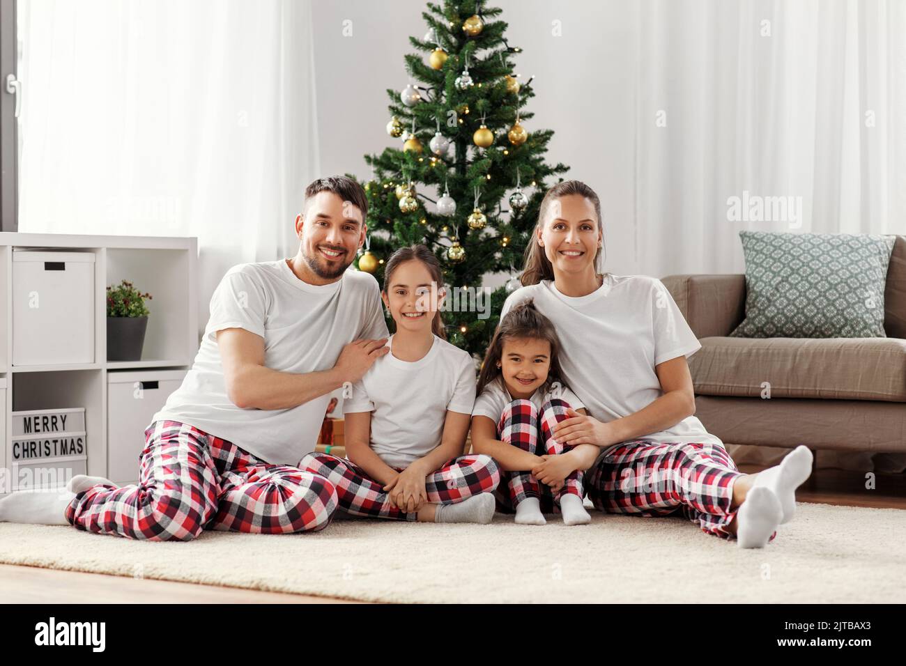 Family sitting under tree hi-res stock photography and images - Alamy