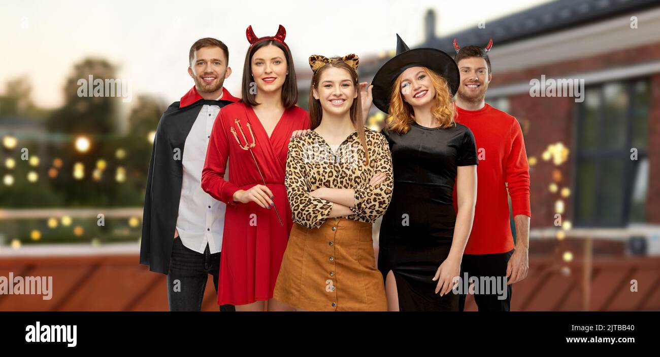 happy friends in halloween costumes over grey Stock Photo - Alamy