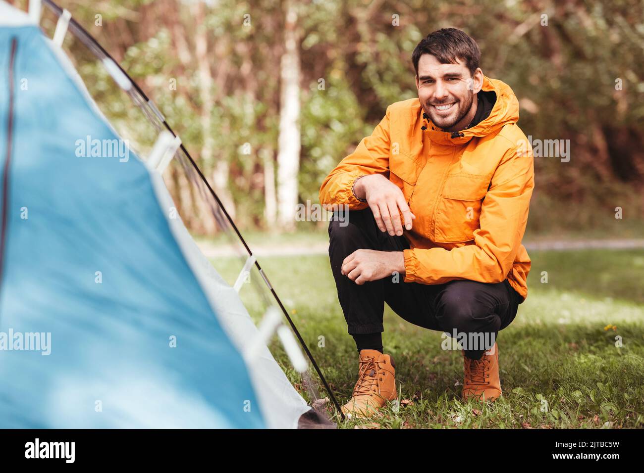 man setting up tent outdoors Stock Photo - Alamy