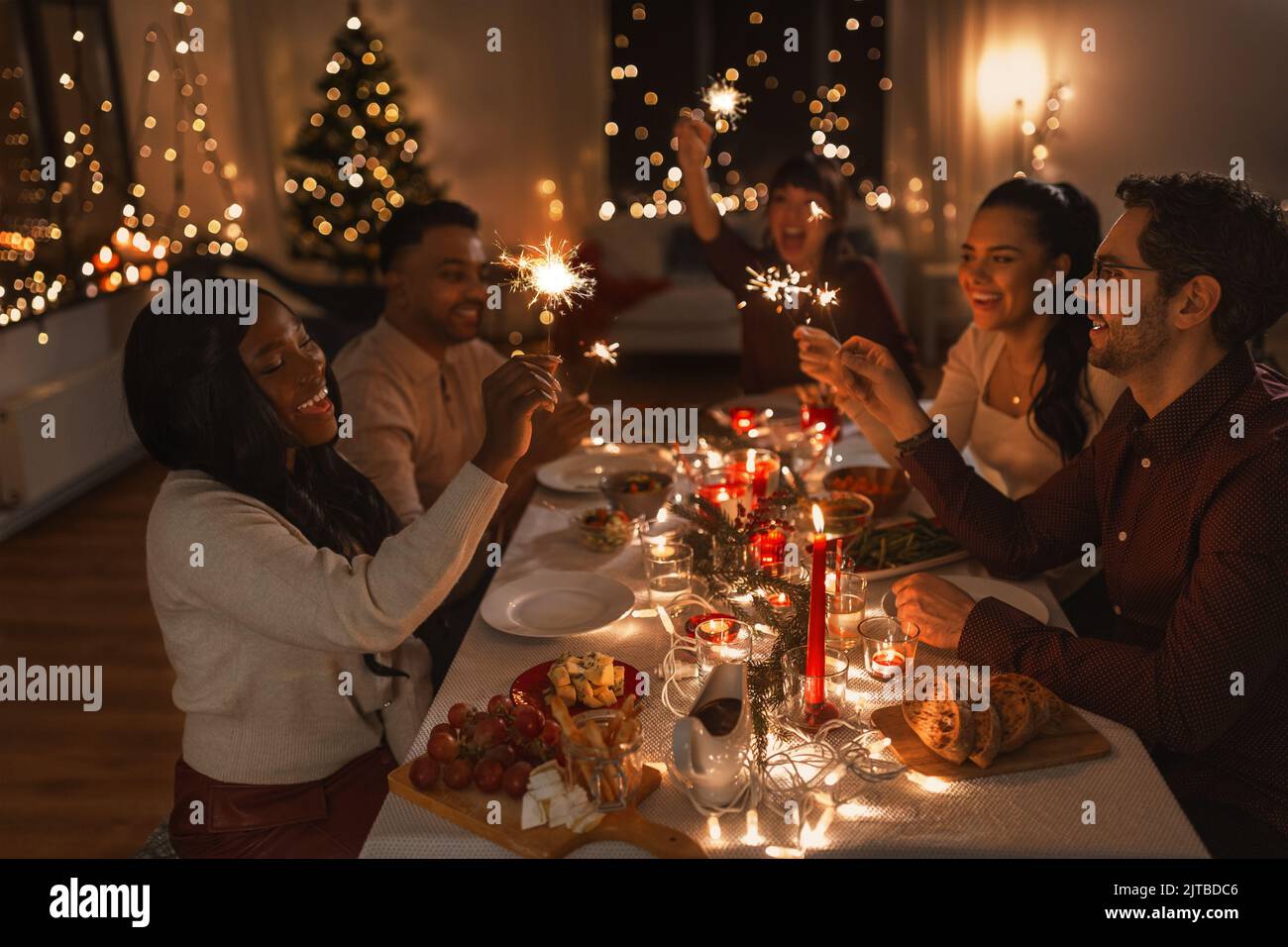 happy friends with sparklers at christmas dinner Stock Photo - Alamy
