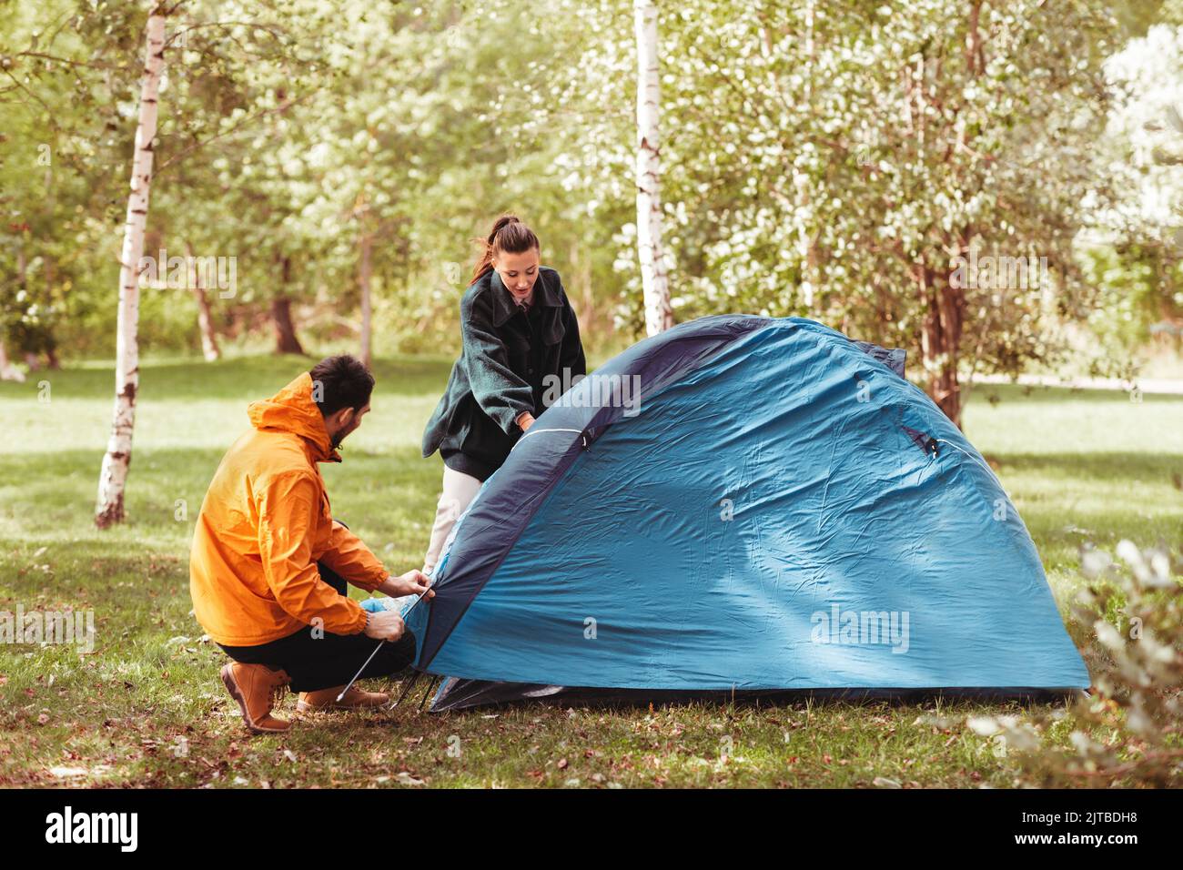 happy couple setting up tent outdoors Stock Photo - Alamy