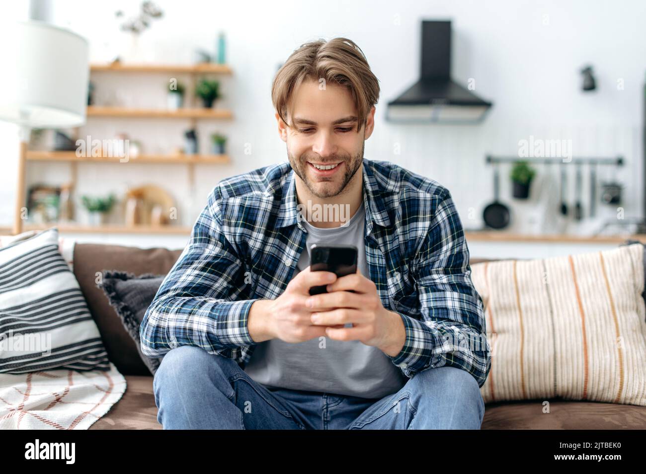 The concept of using gadgets. Attractive positive caucasian guy, sits ...
