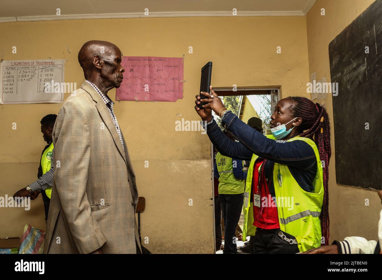 An election official confirms a voter's biometric details using a ...