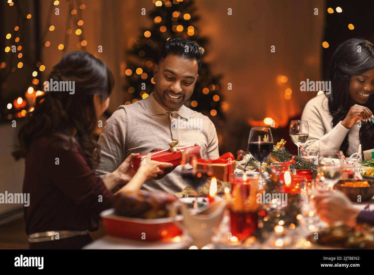 Friends celebrating christmas giving hi-res stock photography and ...
