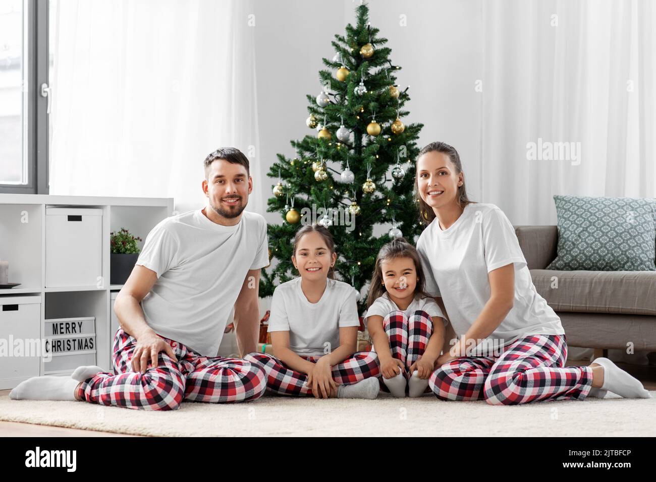 Family sitting under tree hi-res stock photography and images - Alamy
