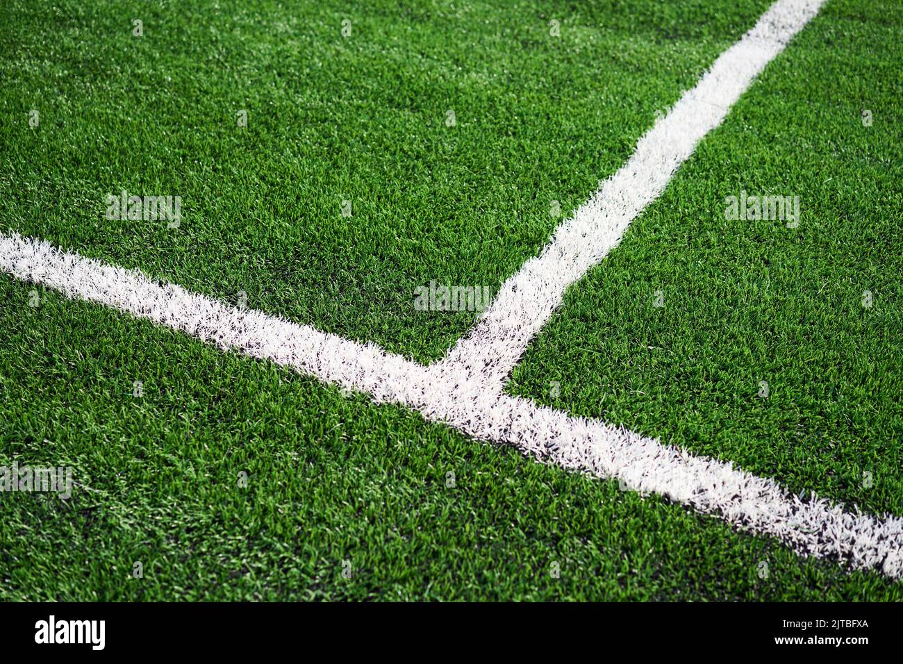 Green synthetic grass sports field with white line. Shot from above ...