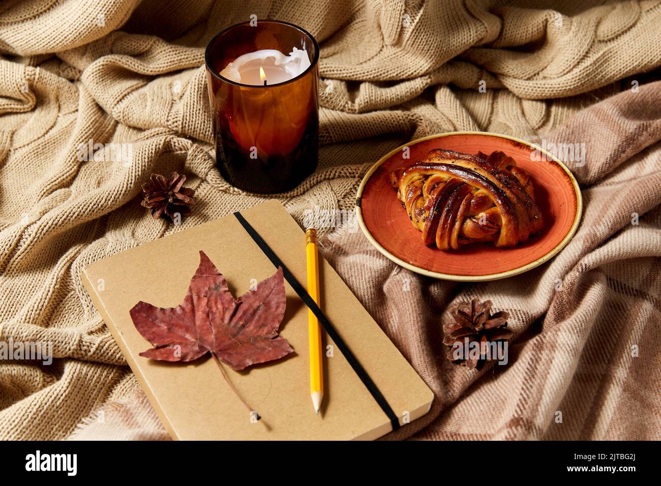 diary, pencil, cinnamon bun and candle in autumn Stock Photo - Alamy