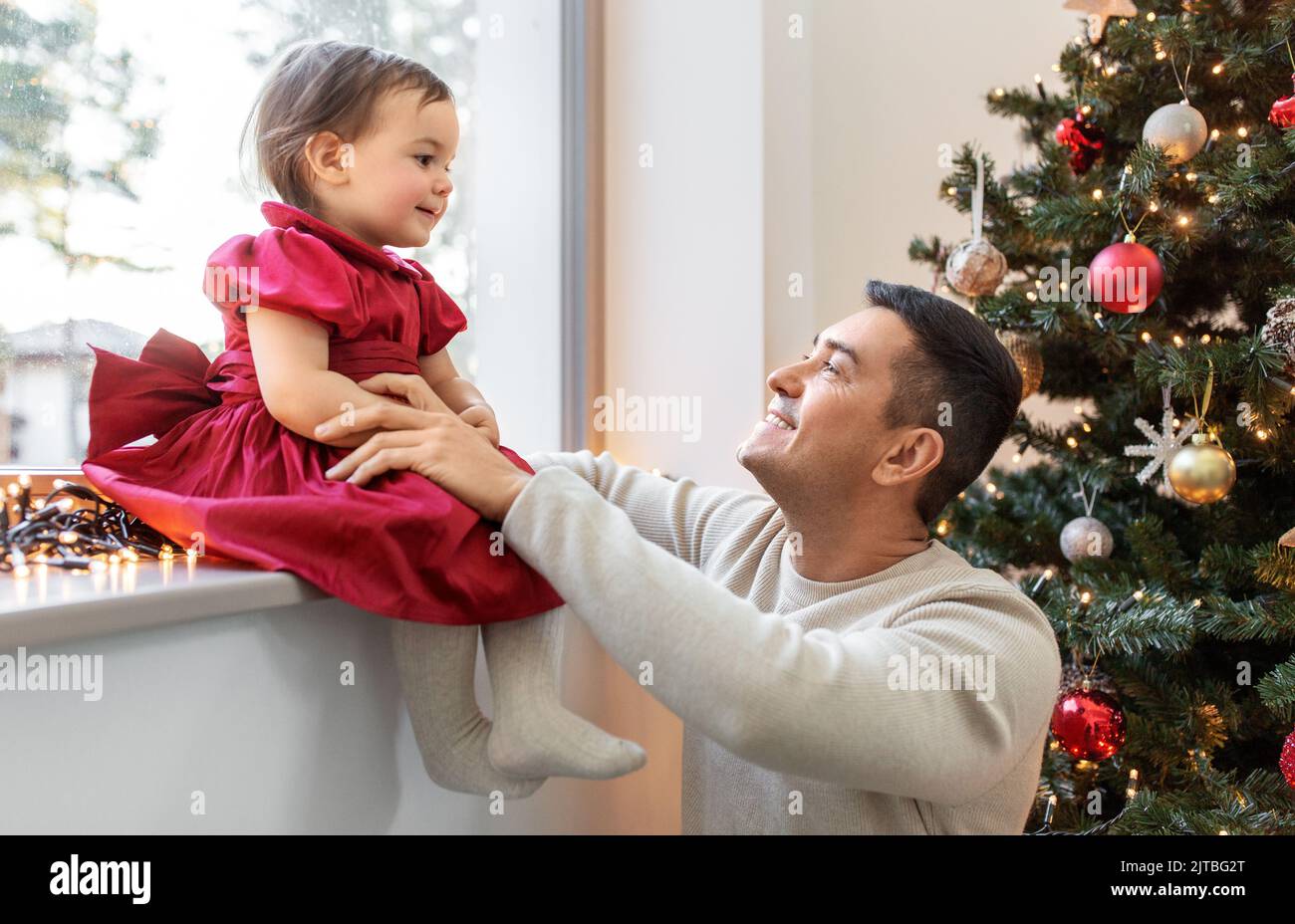 happy father and baby girl over christmas tree Stock Photo - Alamy