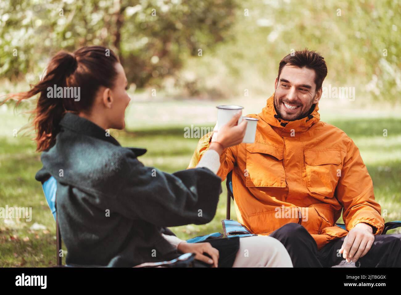 happy couple drinking tea at campsite Stock Photo - Alamy