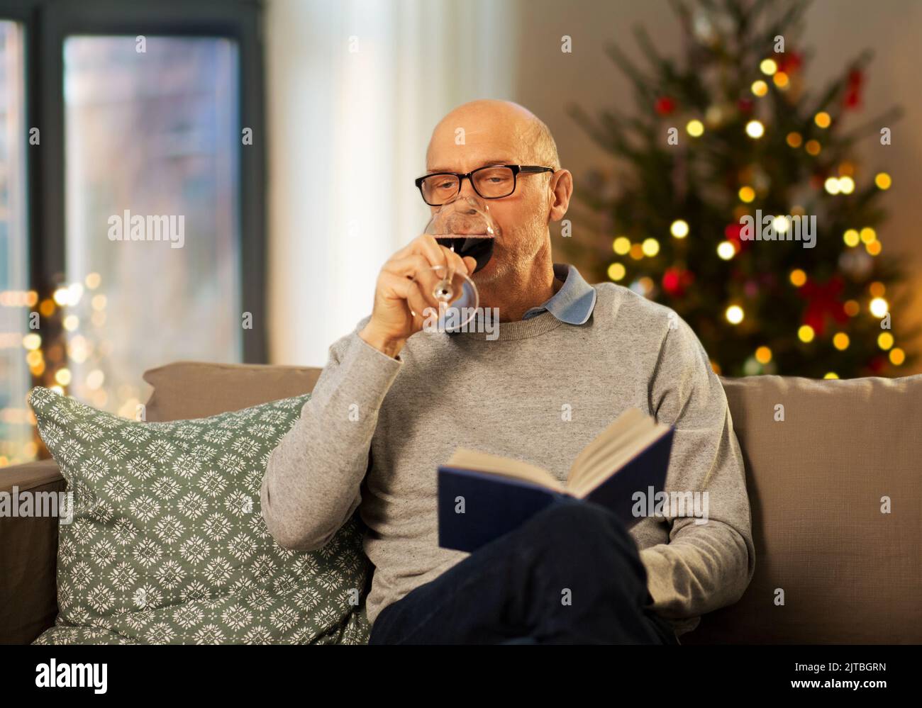 old man with book drinking red wine on christmas Stock Photo - Alamy