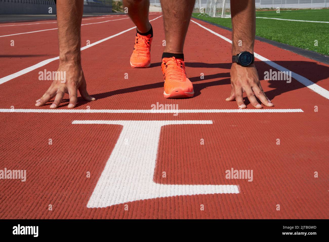 Hands on the starting line, the sprinter is preparing to start at the ...