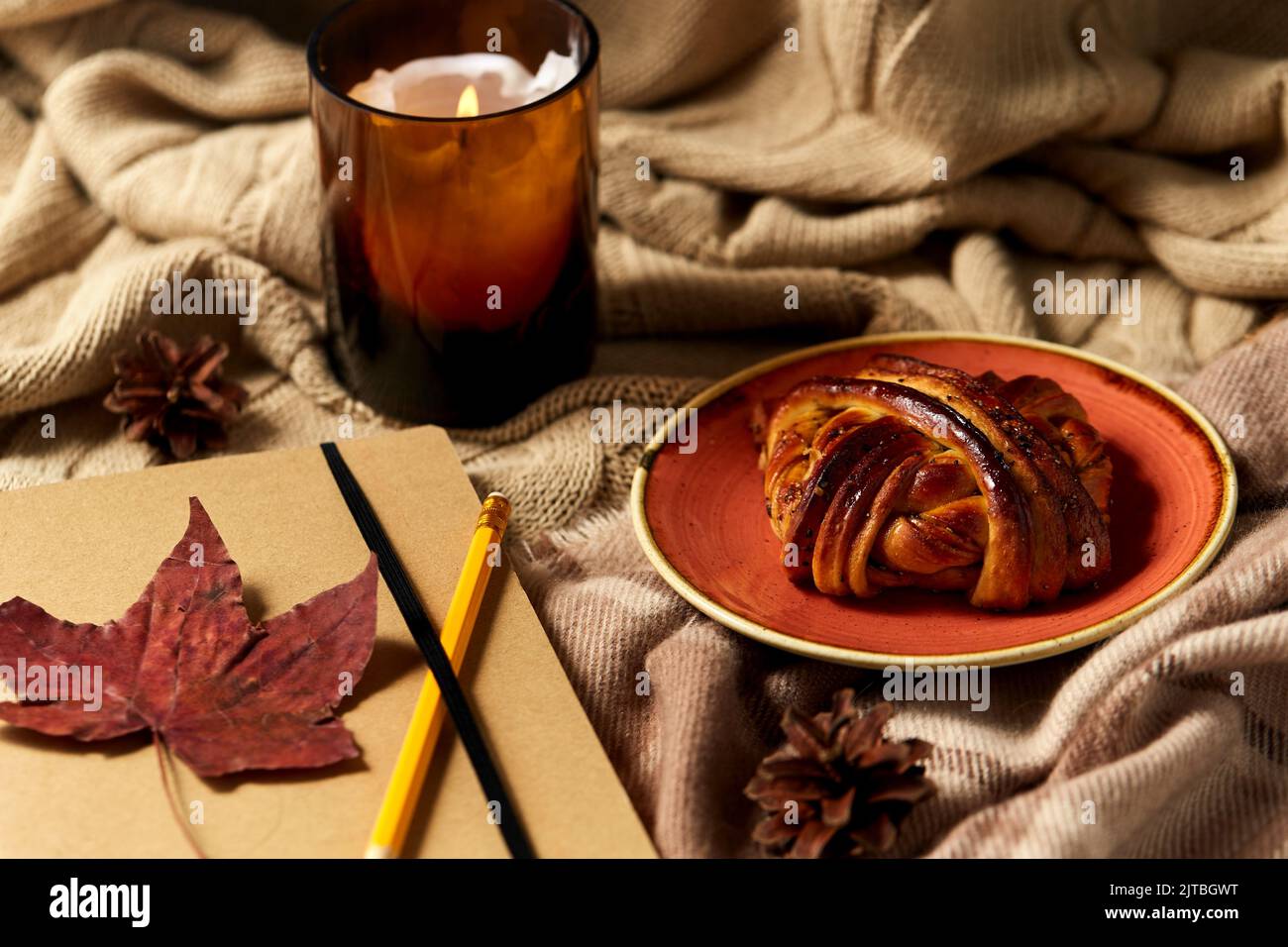 diary, pencil, cinnamon bun and candle in autumn Stock Photo - Alamy