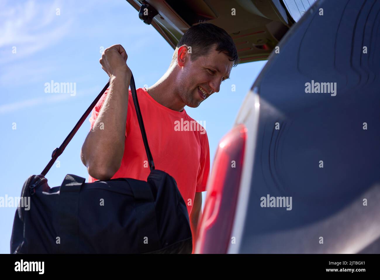 Sportsman getting bag out of trunk outdoors. Concept of sport lifestyle ...