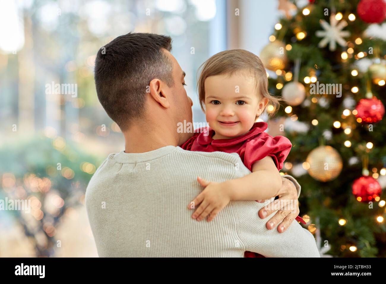 happy father and baby girl over christmas tree Stock Photo - Alamy
