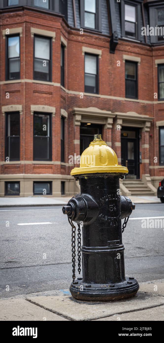 A fire hydrant in front of a brick building Stock Photo - Alamy