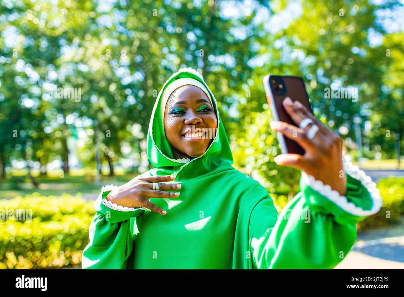 multicultural wwoman in green muslim dress with bright make-up and ...