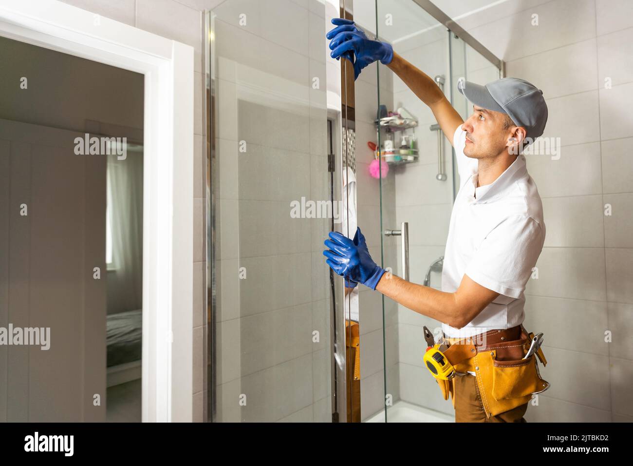 Workers are installing glass door of the shower enclosure Stock Photo ...