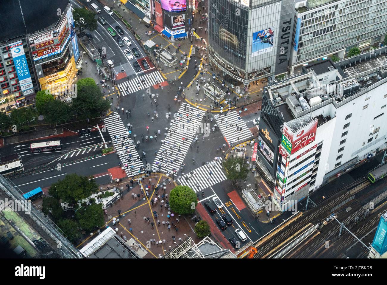 Pedestrians with umbrellas cross the multi-directional scramble crossing intersection known as ...