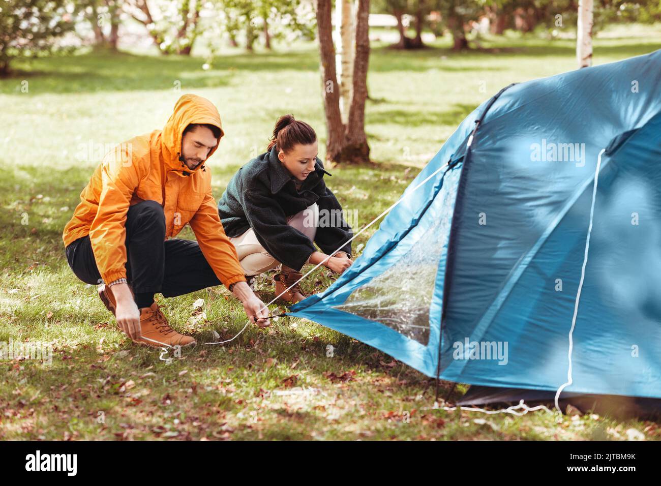 happy couple setting up tent outdoors Stock Photo - Alamy