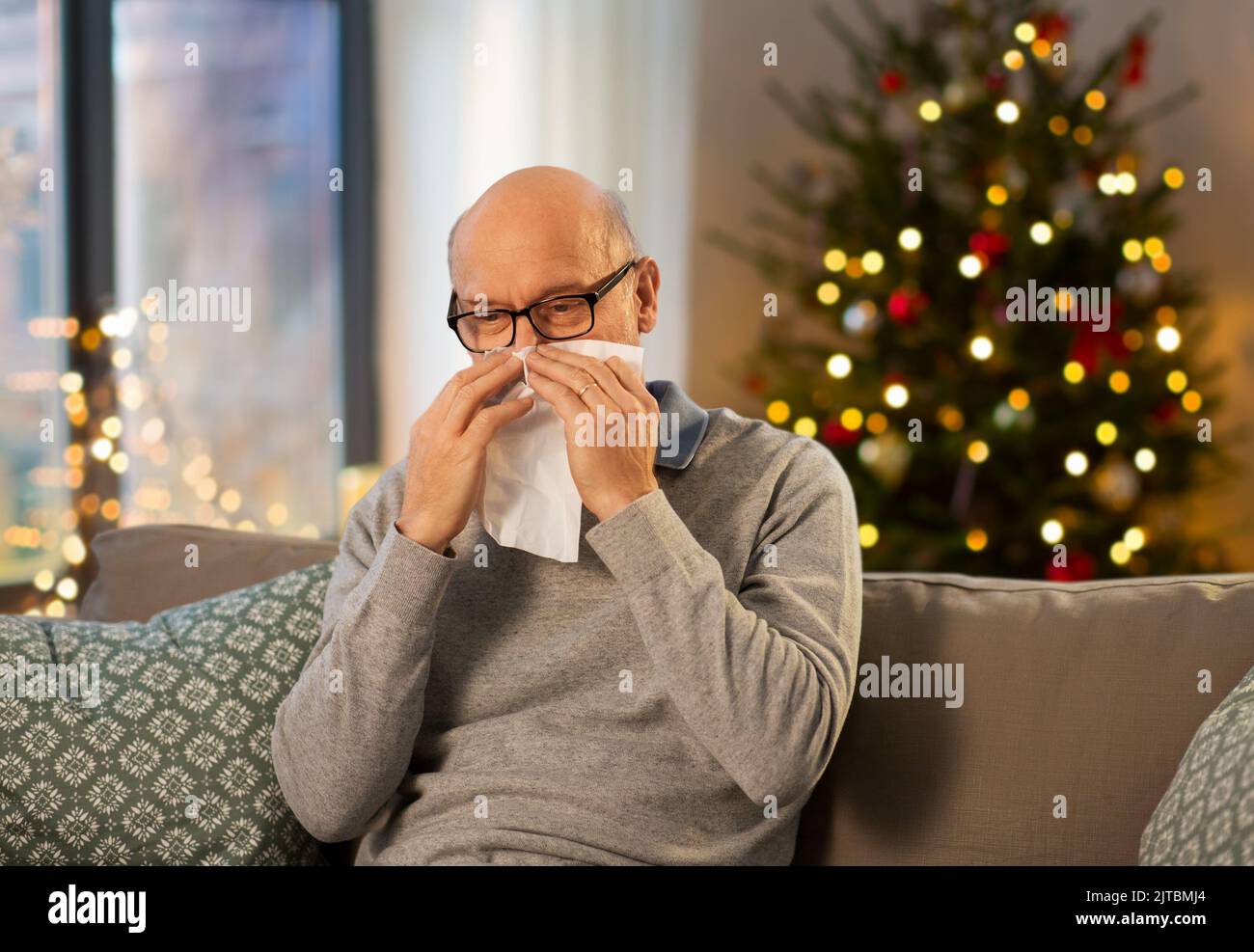 sick senior man blowing nose on christmas Stock Photo - Alamy