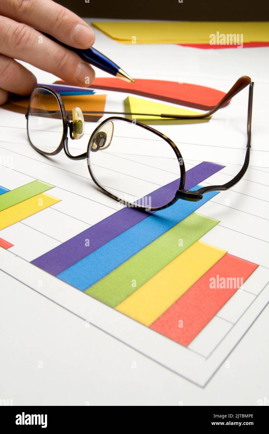 Business Still Life with Eyeglasses and Financial Graphs Vertical Stock ...
