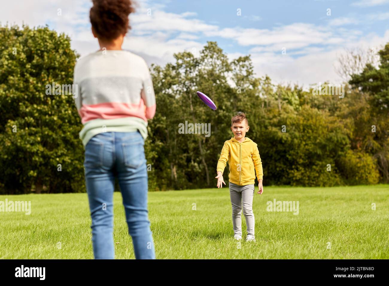 happy children playing with flying disc at park Stock Photo - Alamy