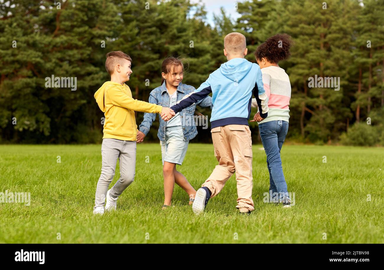 happy children playing round dance at park Stock Photo - Alamy