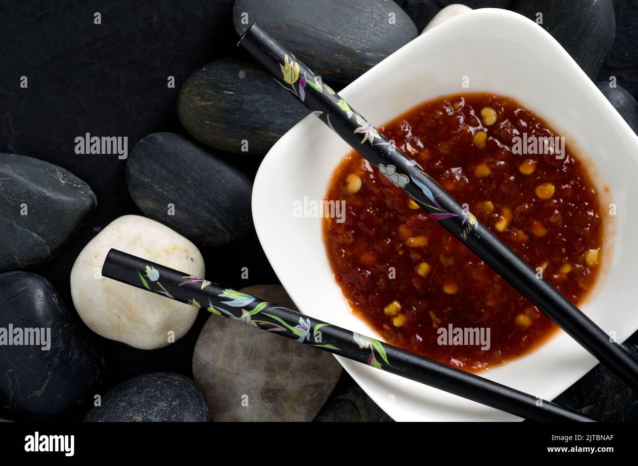 Top View of Sambal Oelek Hot Sauce in White Bowl with Dark Rocks and ...