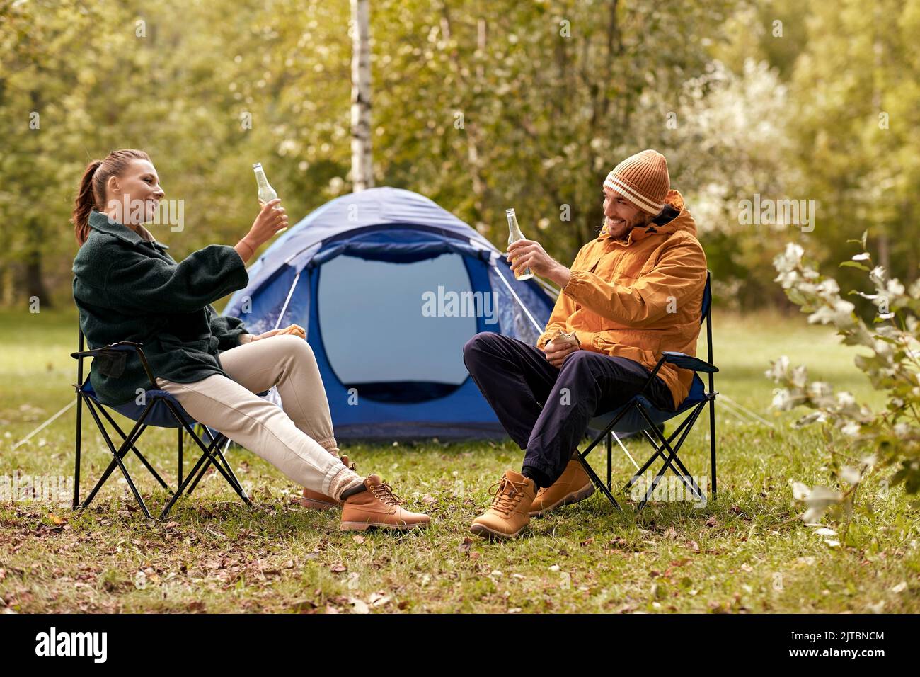 couple drinking beer with sandwiches at tent camp Stock Photo - Alamy
