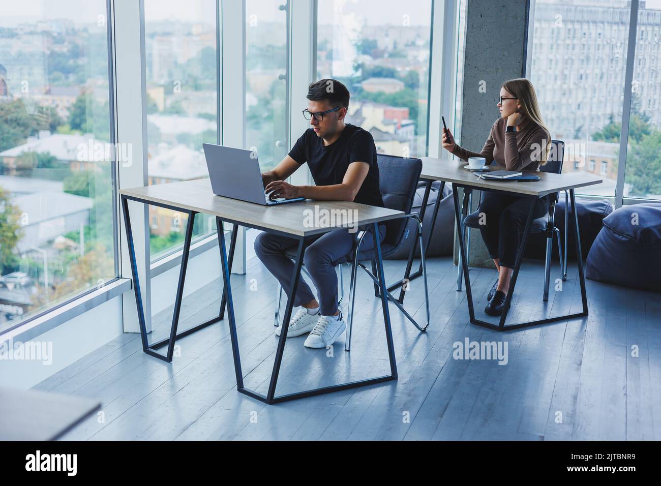 Young colleagues in the office at the desktop with a laptop. Young ...