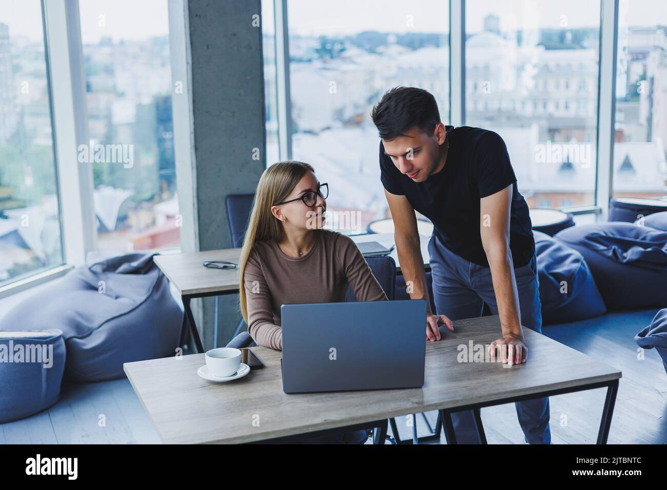 Two colleagues are discussing work on a laptop. Friendly relations in ...