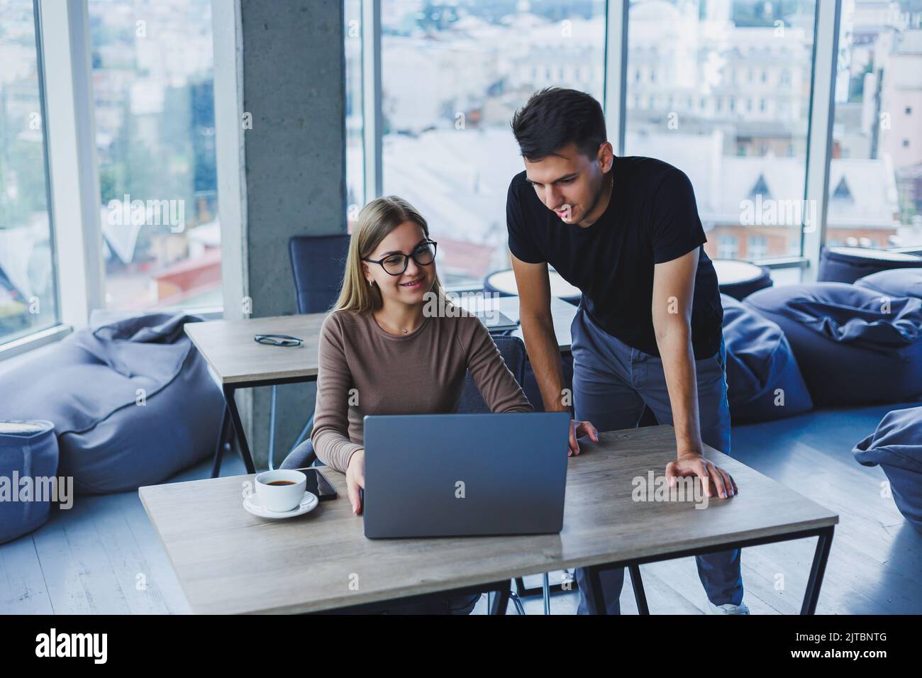 Two colleagues are discussing work on a laptop. Friendly relations in ...