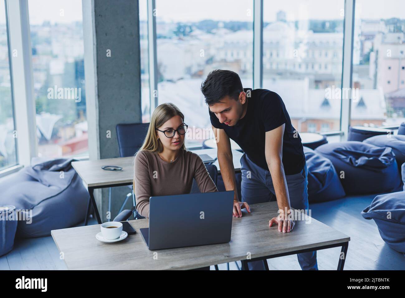 Two colleagues are discussing work on a laptop. Friendly relations in ...