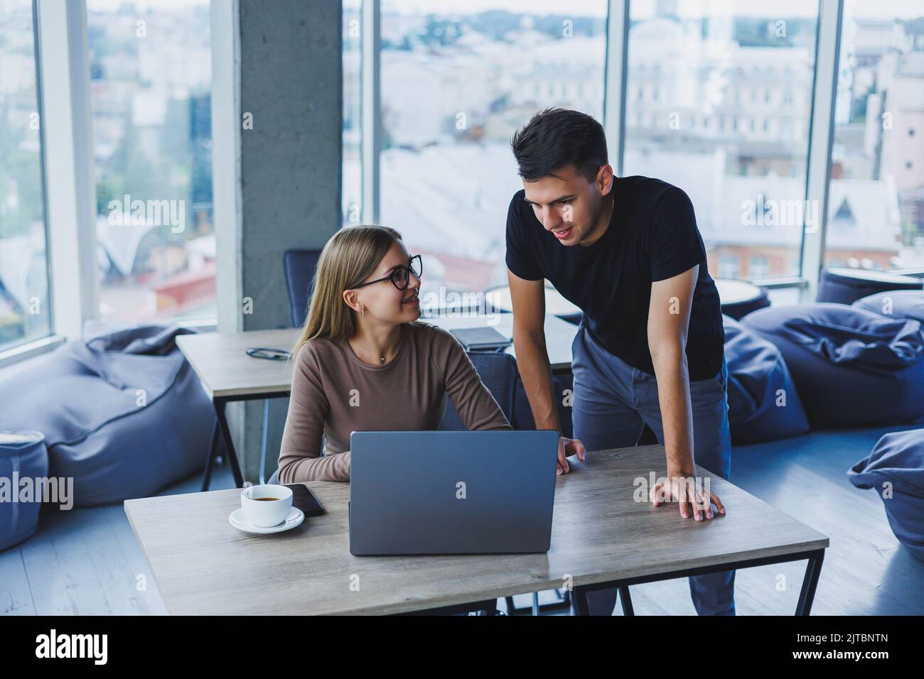 Two colleagues are discussing work on a laptop. Friendly relations in ...