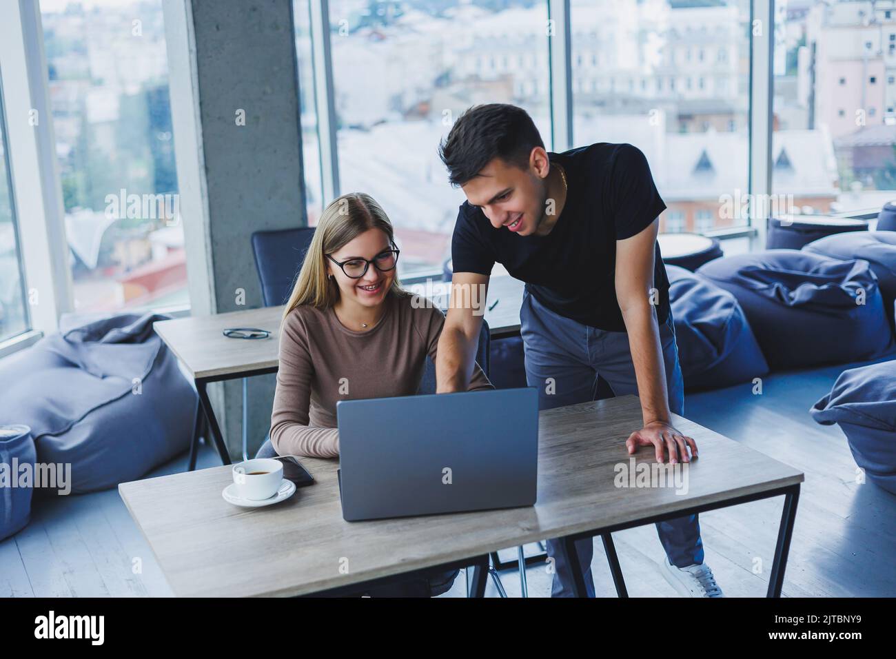 Two colleagues are discussing work on a laptop. Friendly relations in ...