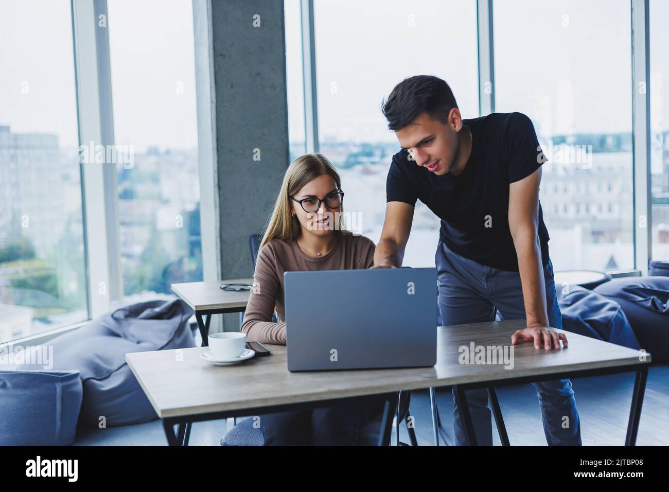 Two colleagues are discussing work on a laptop. Friendly relations in ...
