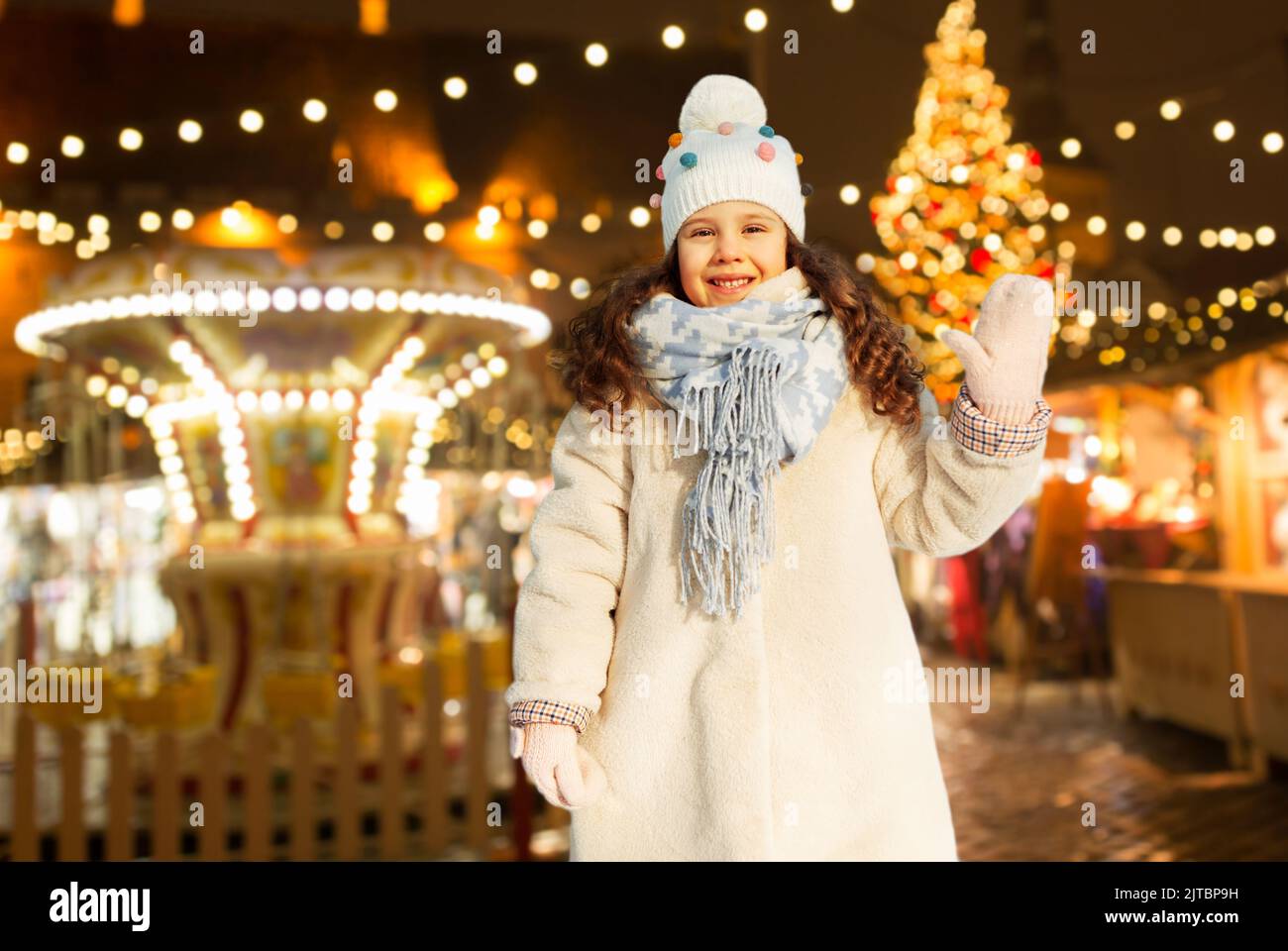happy little girl waving hand at christmas market Stock Photo - Alamy