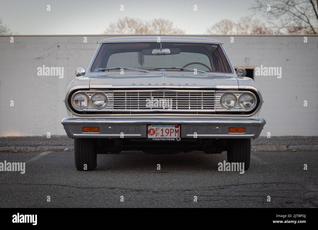 A restored old car after being cleaned and polished in the parking lot ...