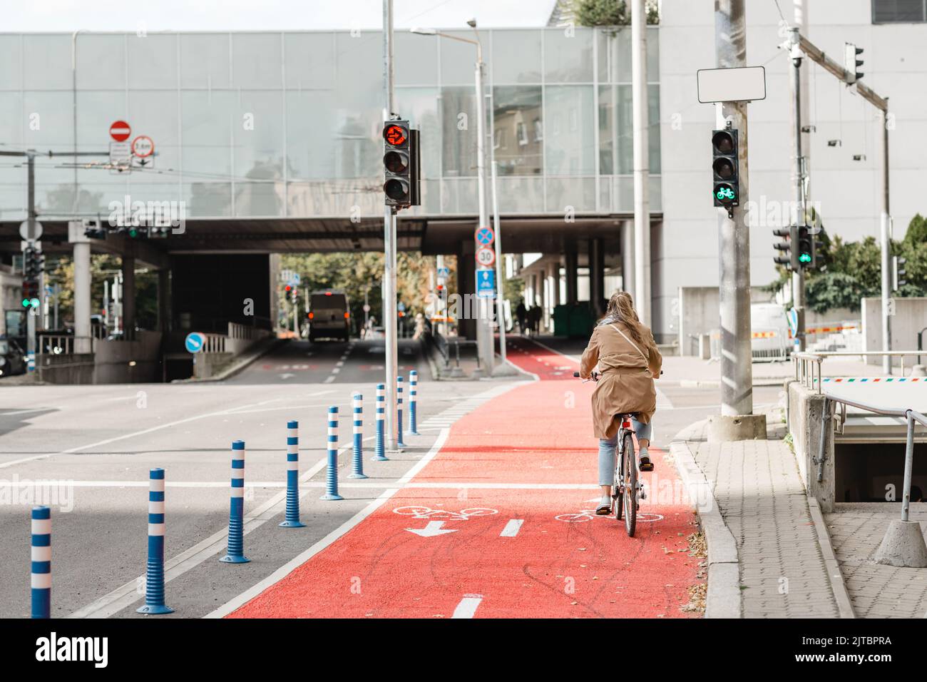 woman cycling along red bike lane road in city Stock Photo - Alamy