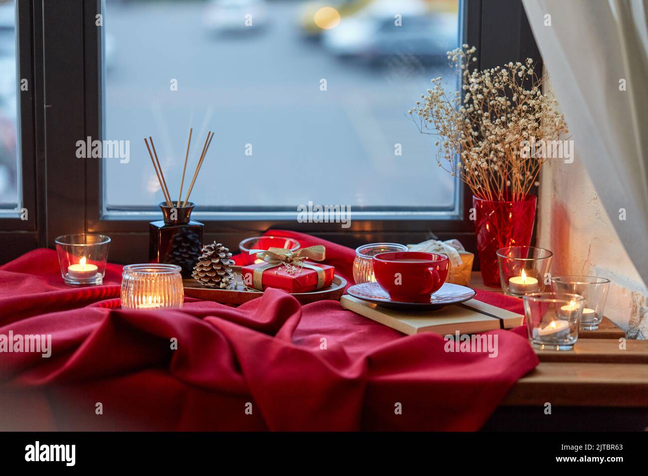 christmas gift, candles and coffee on window sill Stock Photo - Alamy