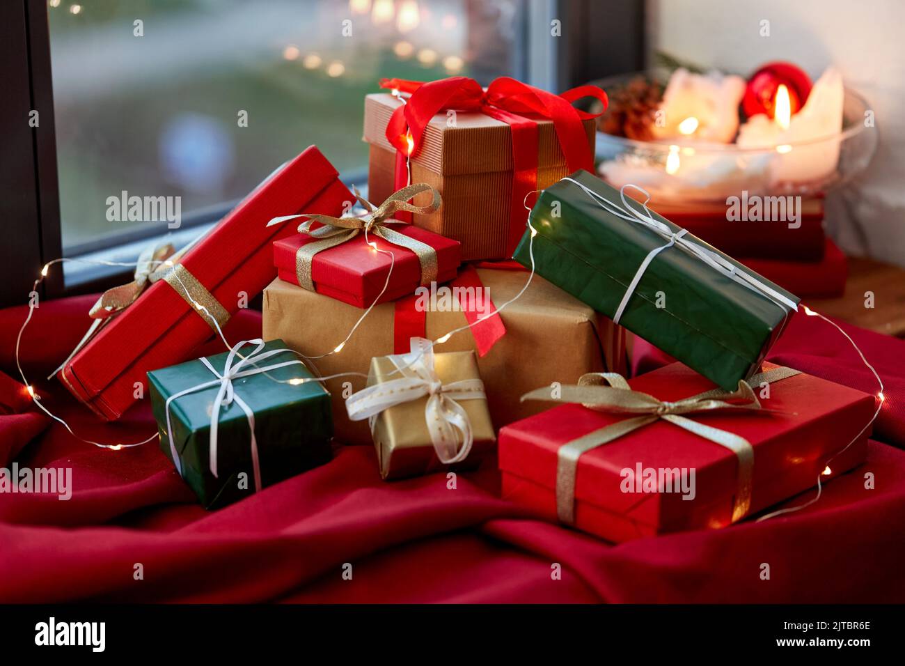 christmas gifts on red tablecloth on window sill Stock Photo - Alamy