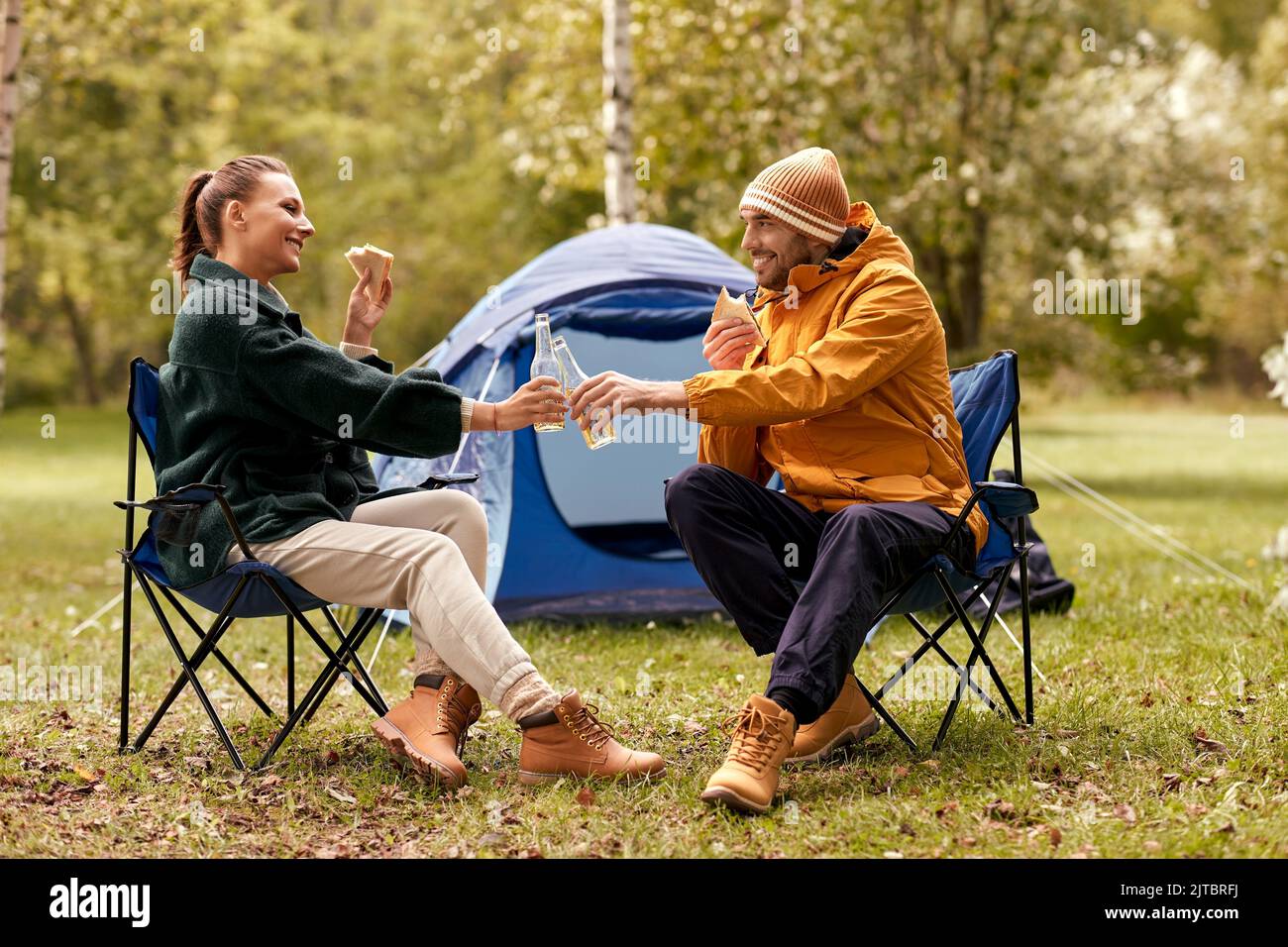 couple drinking beer with sandwiches at tent camp Stock Photo - Alamy