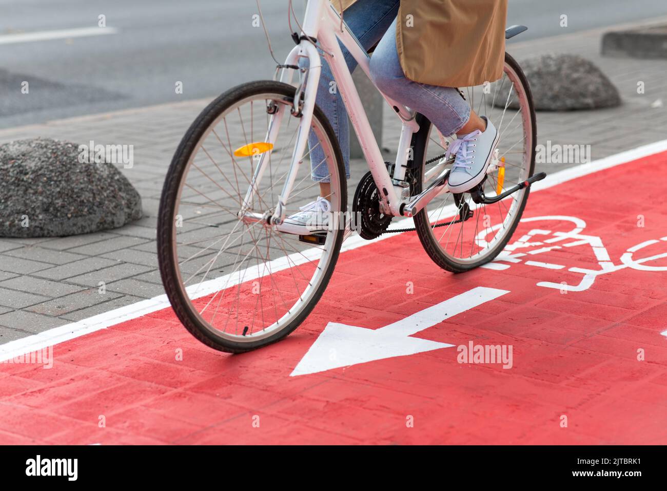 woman cycling along red bike lane road in city Stock Photo - Alamy