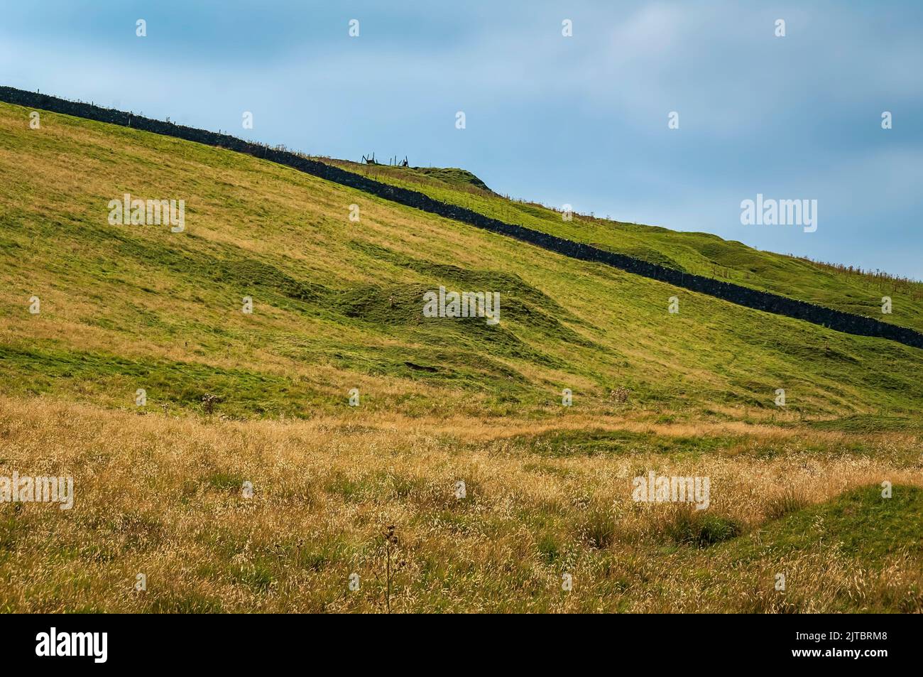 Prominent hillocks from ancient lead mining on a mineral vein high on a ...