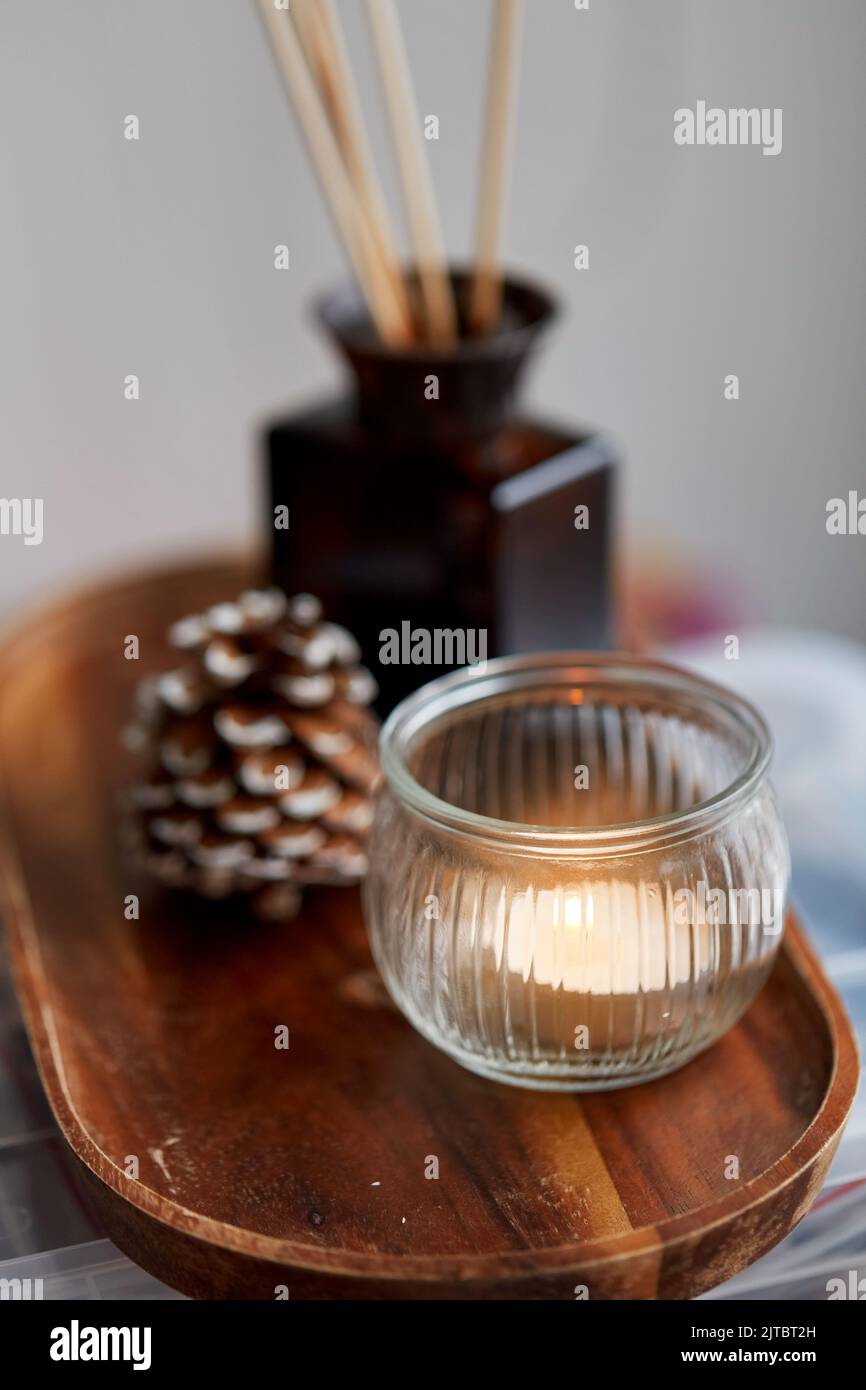 candle holder, reed diffuser and pine cone at home Stock Photo - Alamy