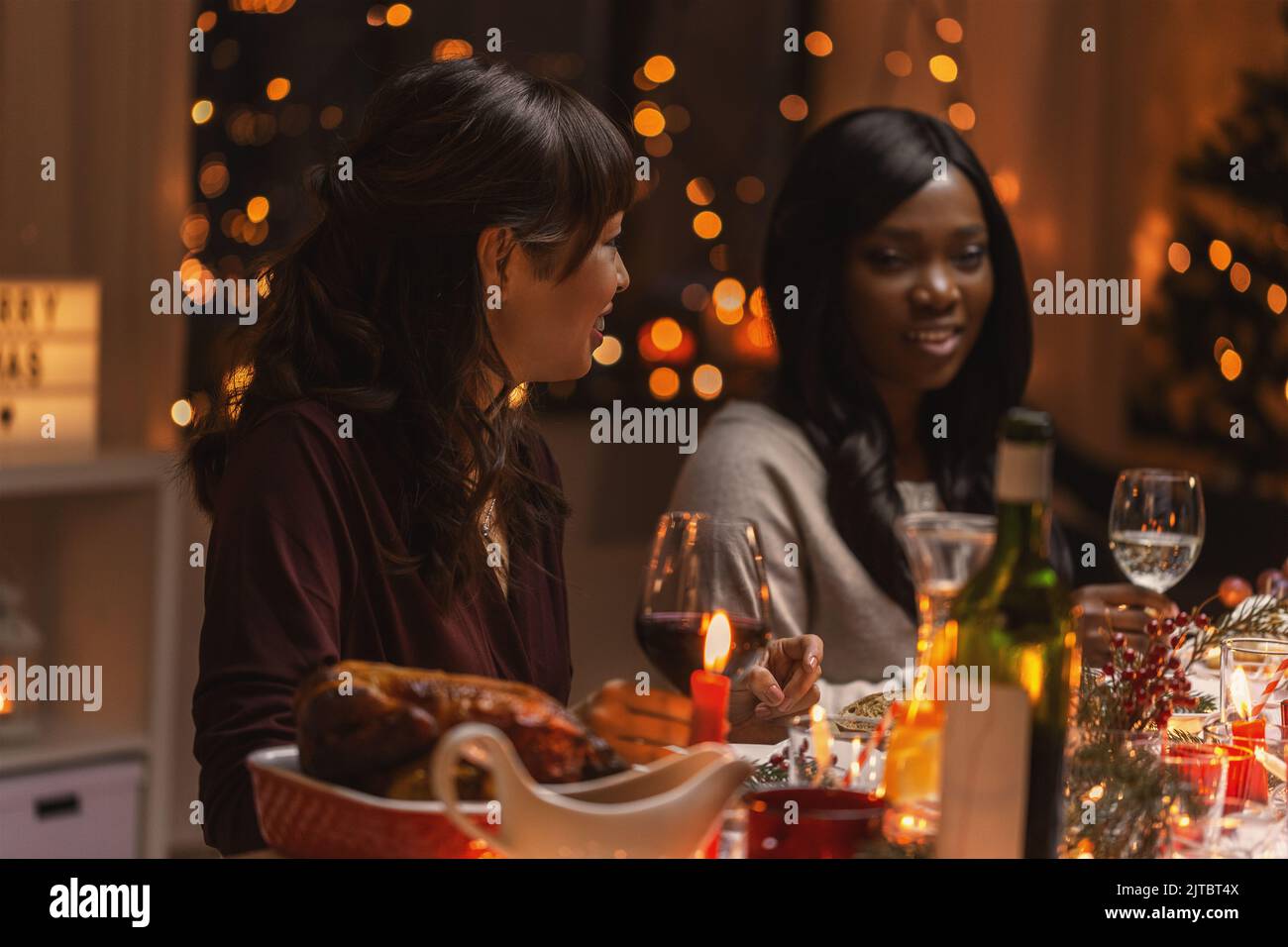 happy women having christmas dinner at home Stock Photo - Alamy