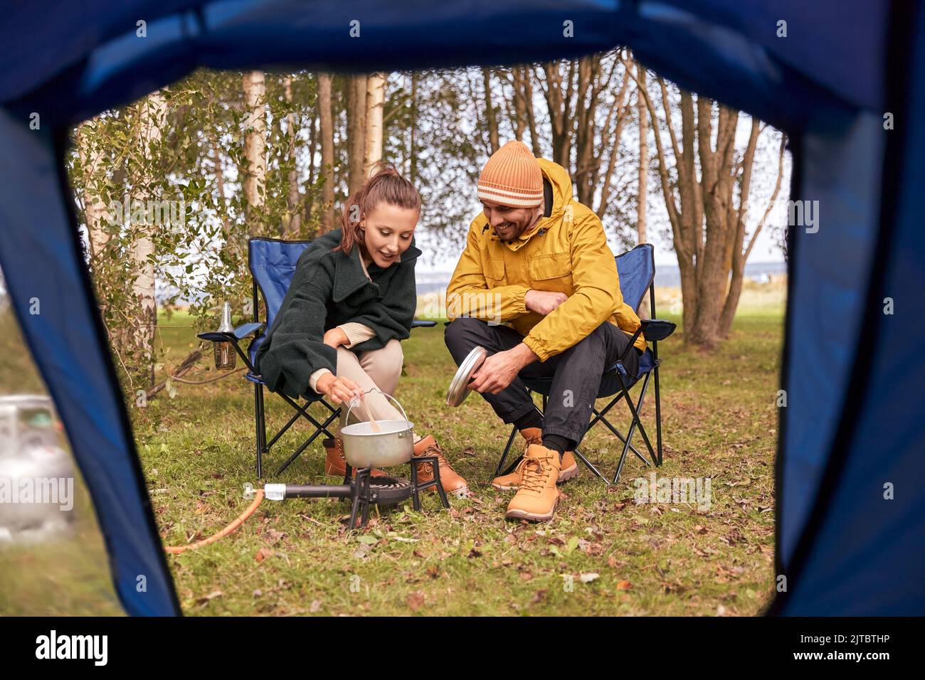 couple cooking food on gas burner at tent camp Stock Photo - Alamy
